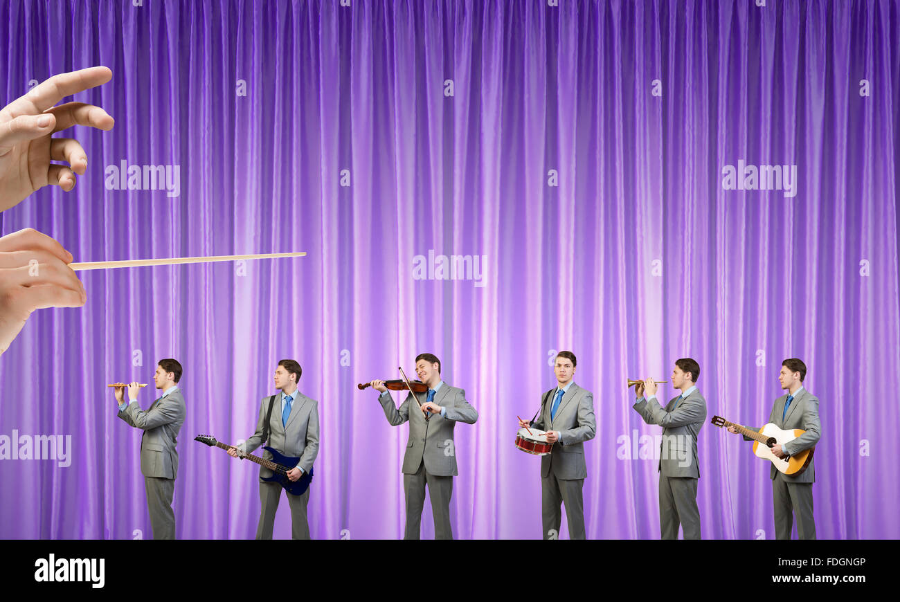 Man orchestra in suit playing different music instruments Stock Photo ...