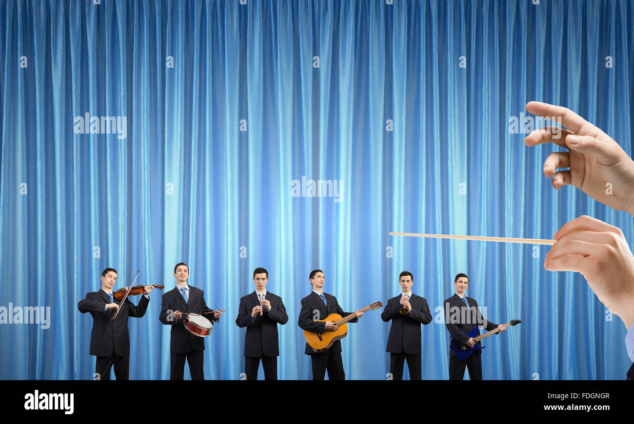 Man orchestra in suit playing different music instruments Stock Photo ...