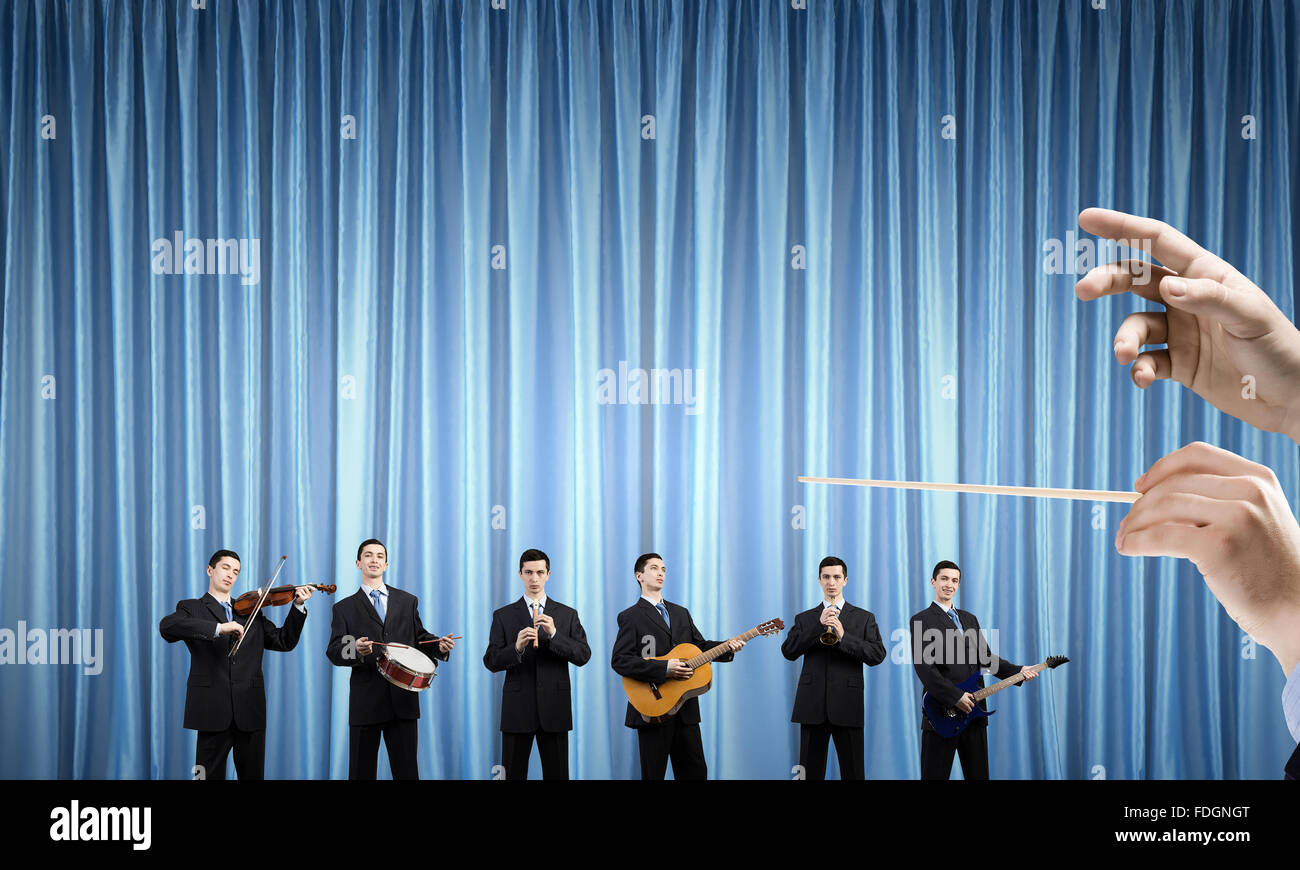 Man orchestra in suit playing different music instruments Stock Photo ...