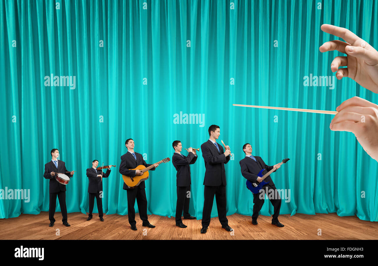 Man orchestra in suit playing different music instruments Stock Photo ...