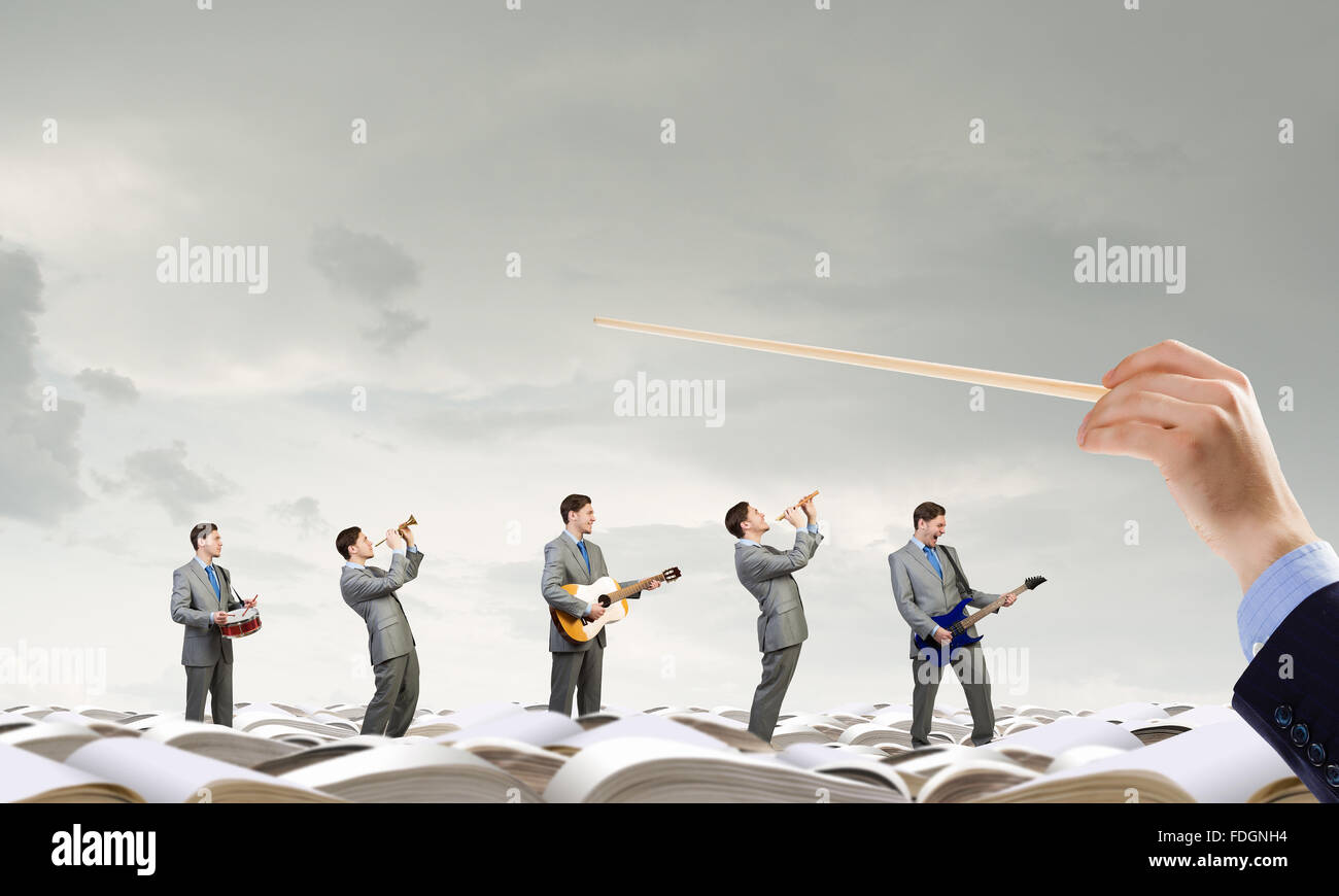 Man orchestra in suit playing different music instruments Stock Photo ...
