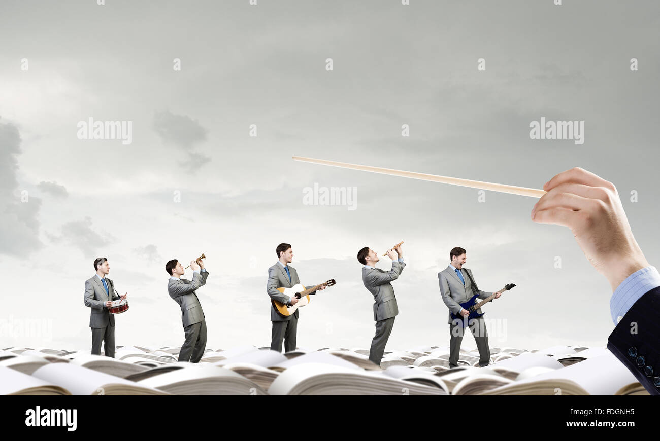 Man orchestra in suit playing different music instruments Stock Photo ...