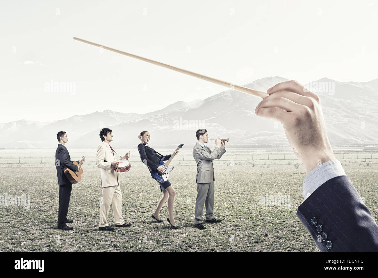 Conductor hand and business people playing different music instruments ...