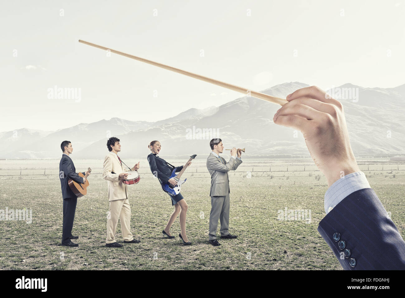 Conductor hand and business people playing different music instruments ...