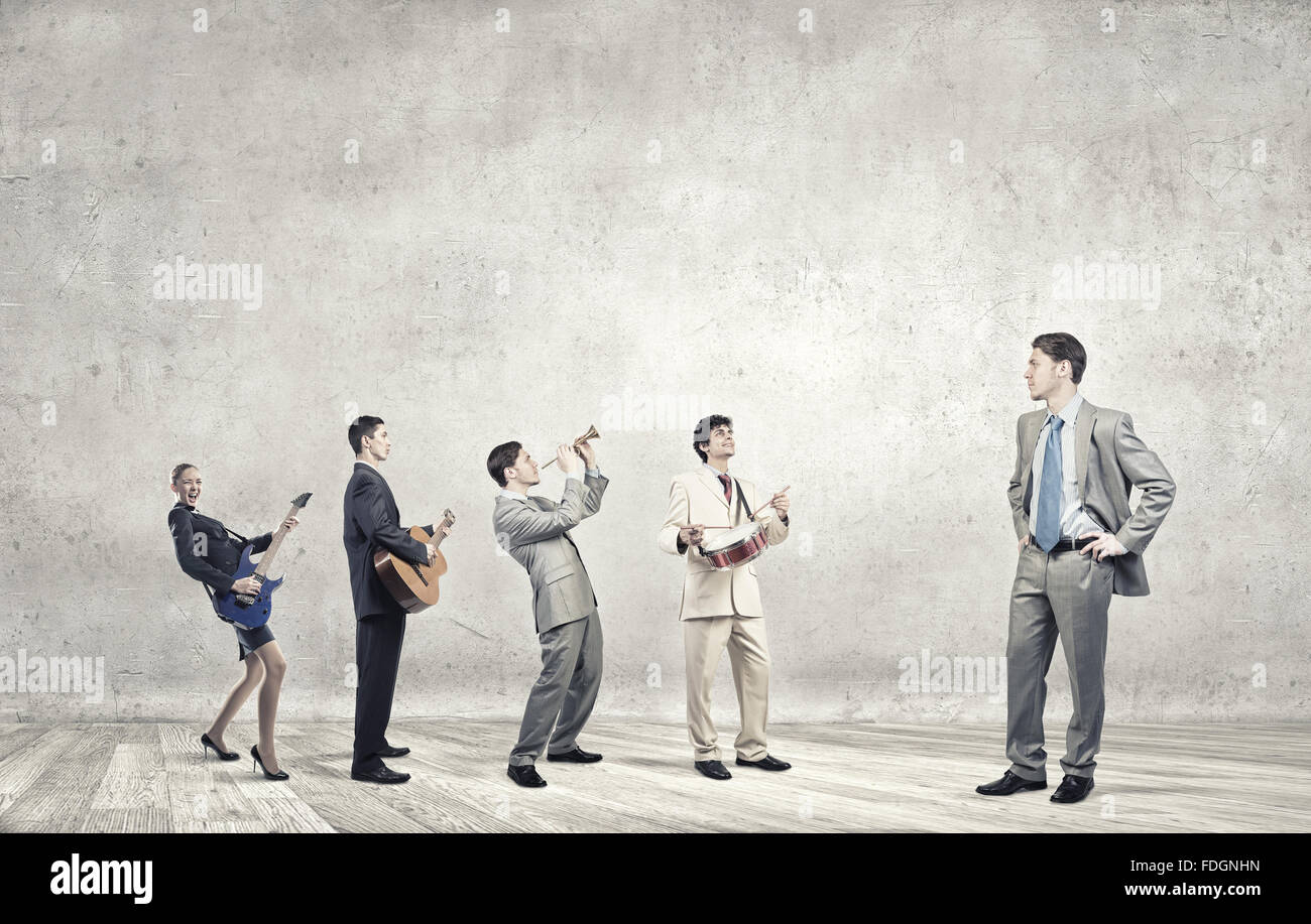 Conductor hand and business people playing different music instruments ...