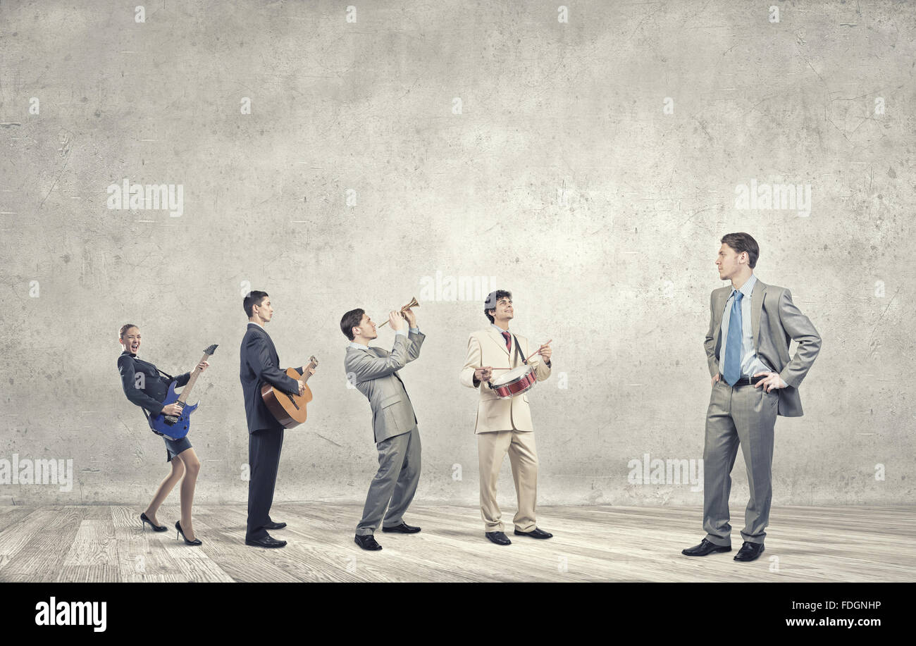 Conductor hand and business people playing different music instruments ...