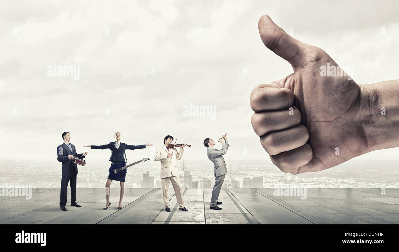 Conductor hand and business people playing different music instruments ...