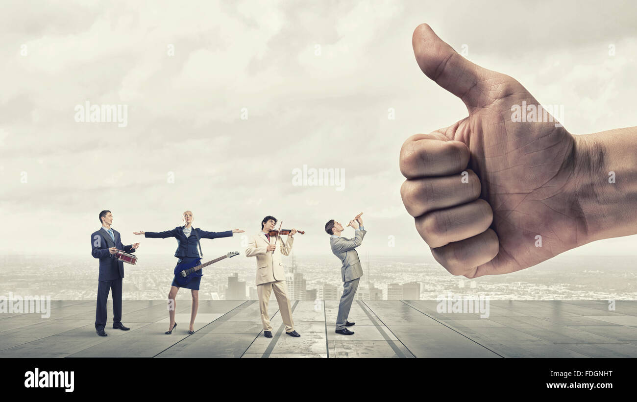 Conductor hand and business people playing different music instruments ...