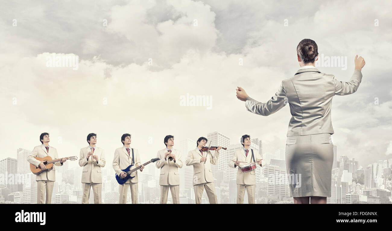 Man orchestra playing different music instruments and woman leader ...