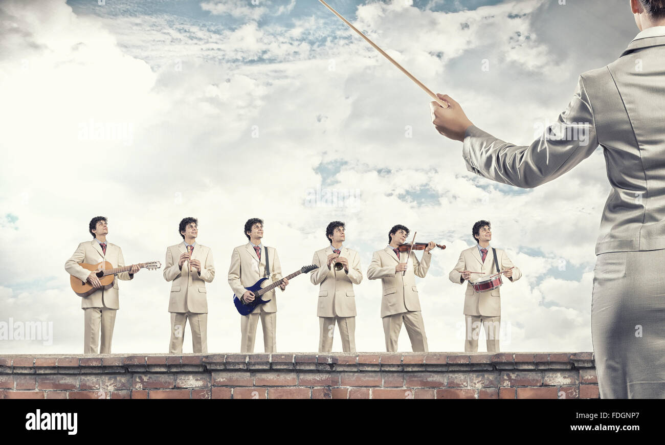 Man orchestra playing different music instruments and woman leader ...