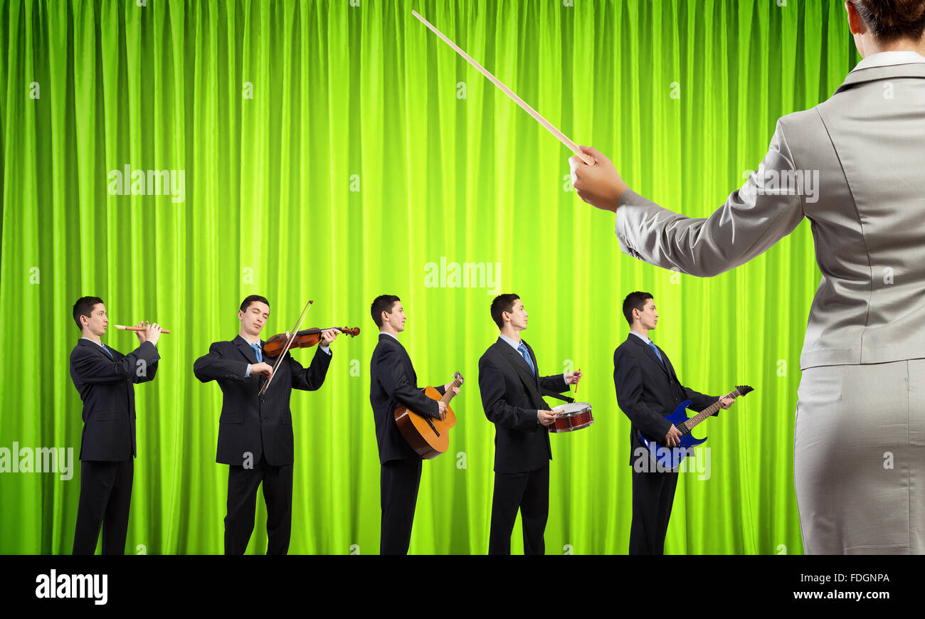 Man orchestra playing different music instruments and woman leader ...