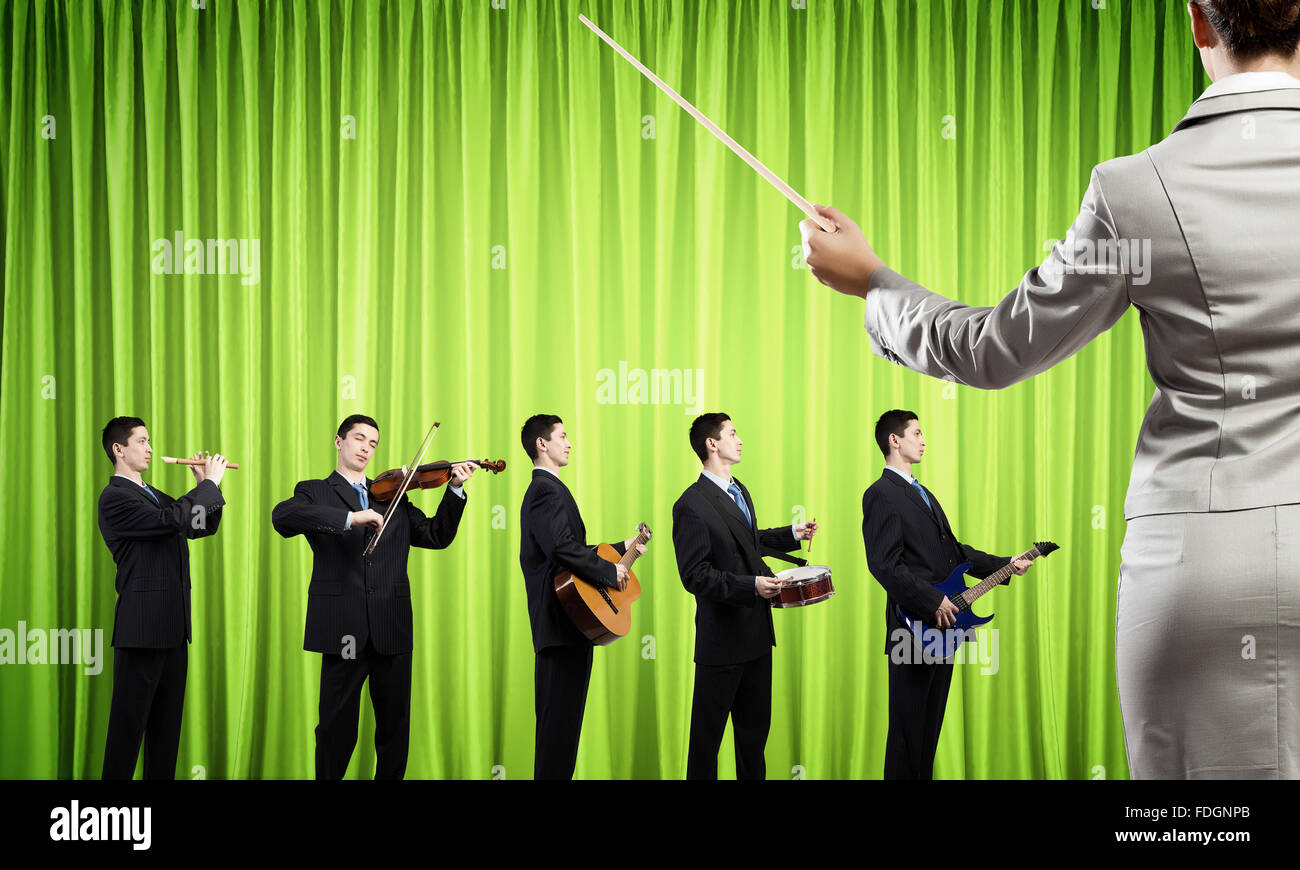 Man orchestra playing different music instruments and woman leader ...