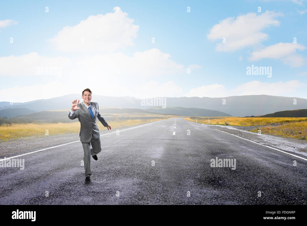 Young businessman in suit running on asphalt road Stock Photo - Alamy