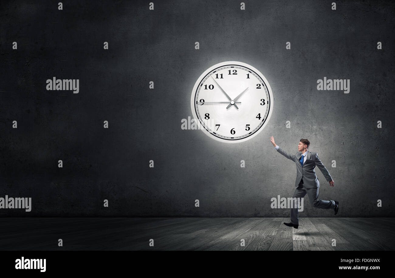 Businessman running and trying to catch time Stock Photo - Alamy Businessman running and trying to catch time Stock Photo - Alamy