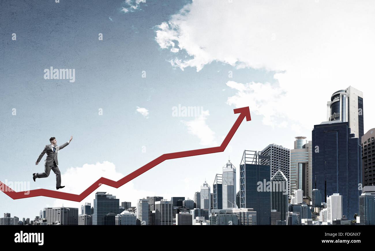 Young businessman running on increasing arrow graph Stock Photo - Alamy