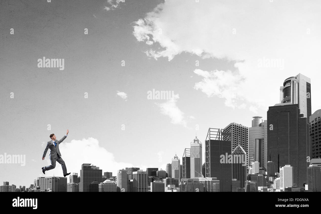 Young businessman running over city buildings and skyscrapers Stock ...