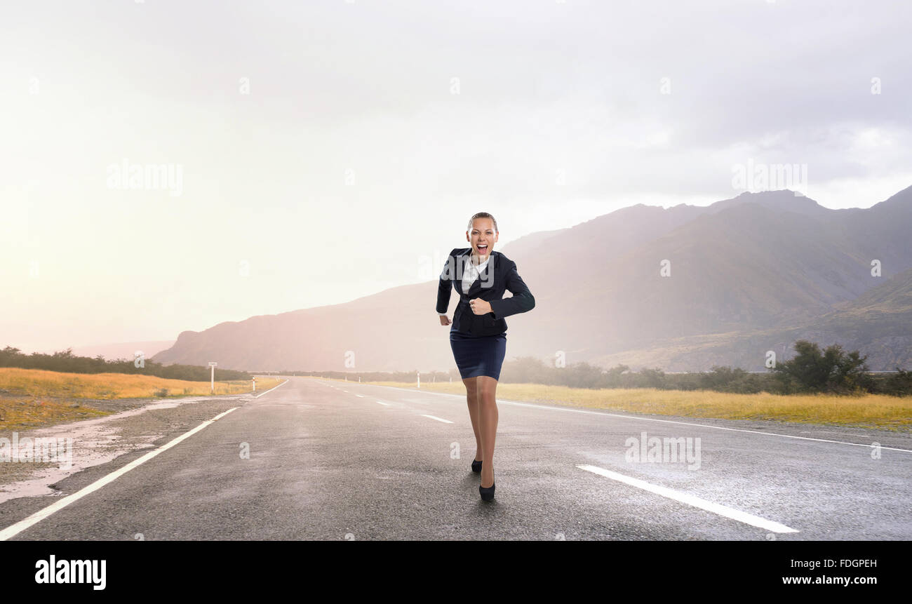 Young determined businesswoman competitor running on road Stock Photo ...