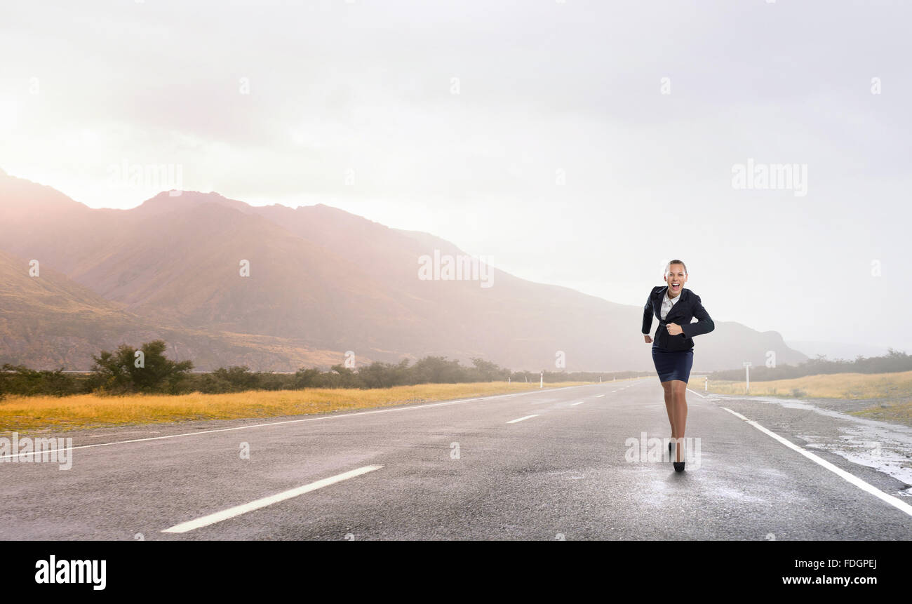 Young determined businesswoman competitor running on road Stock Photo ...