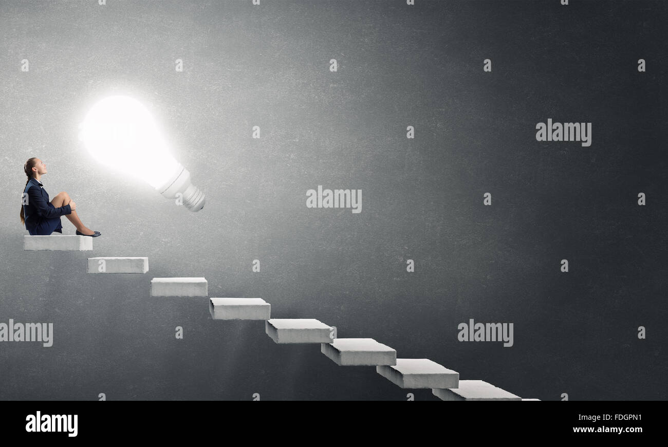 Bored young businesswoman sitting alone on ladder steps Stock Photo - Alamy