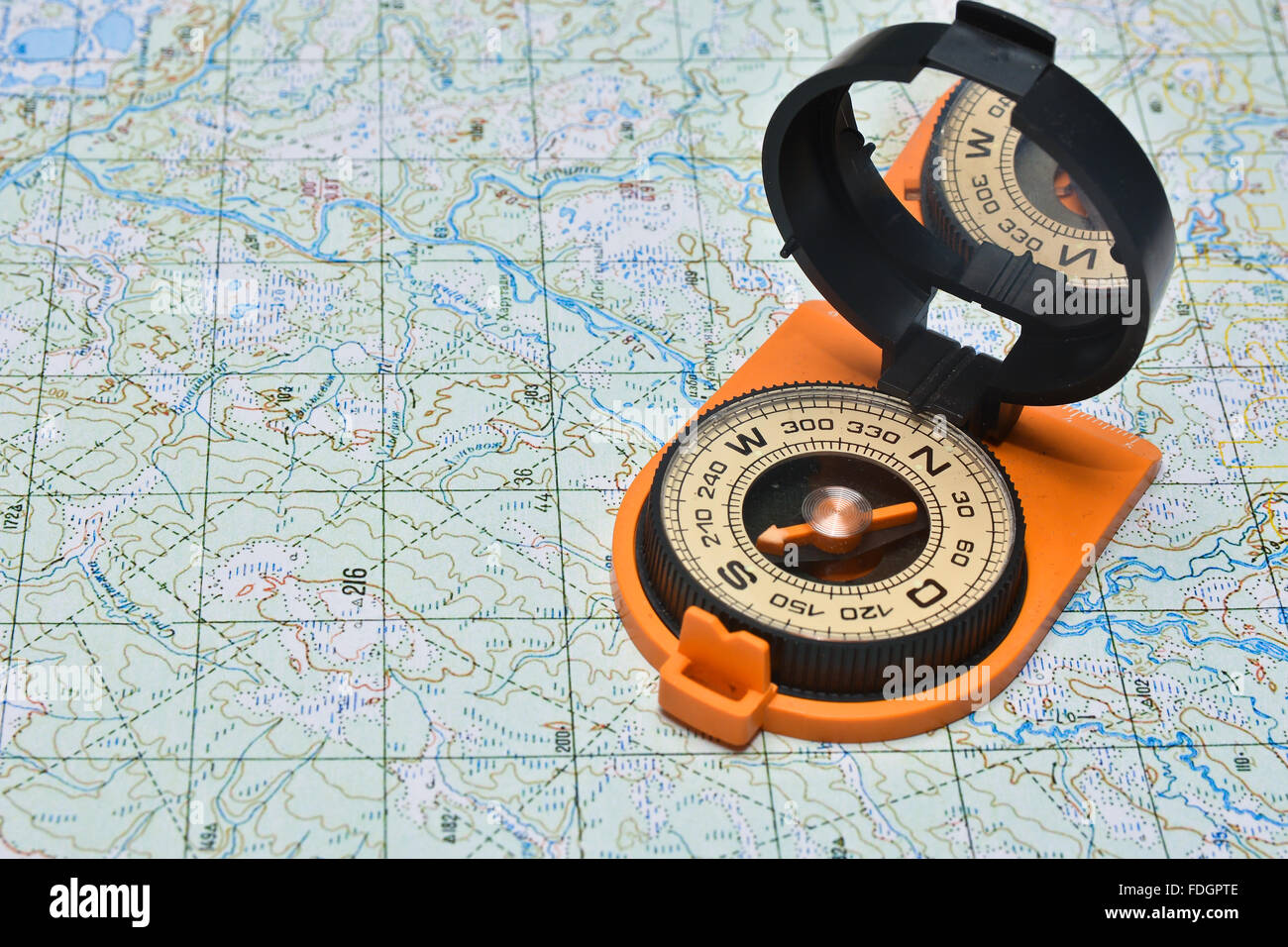 Compass and map. The magnetic compass is lying on a topographical map ...