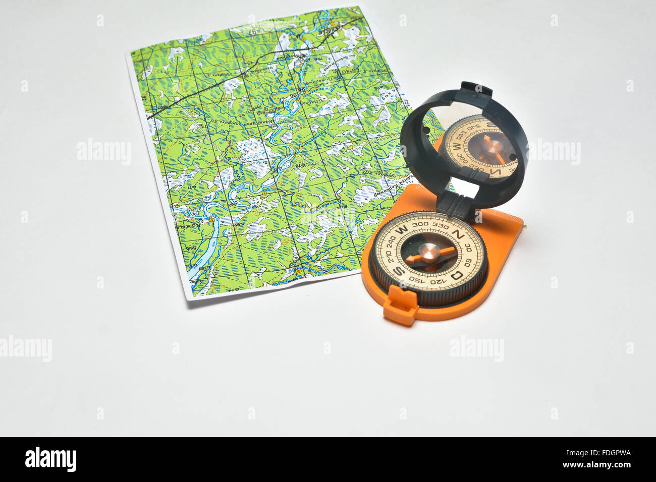 Compass and map. The magnetic compass is lying on a topographical map ...