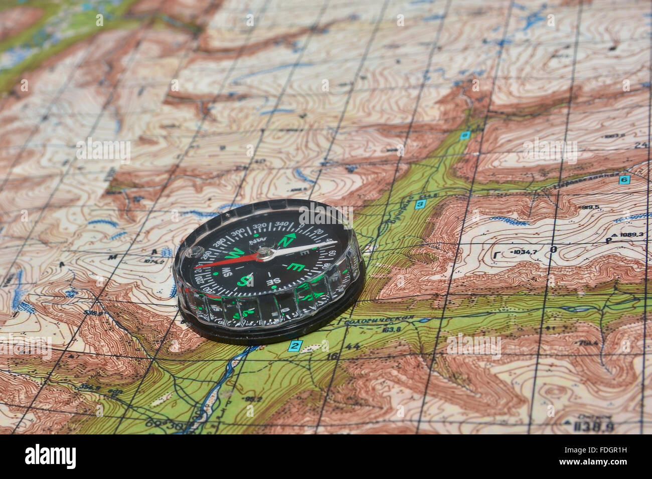 Compass and map. The magnetic compass is lying on a topographical map ...