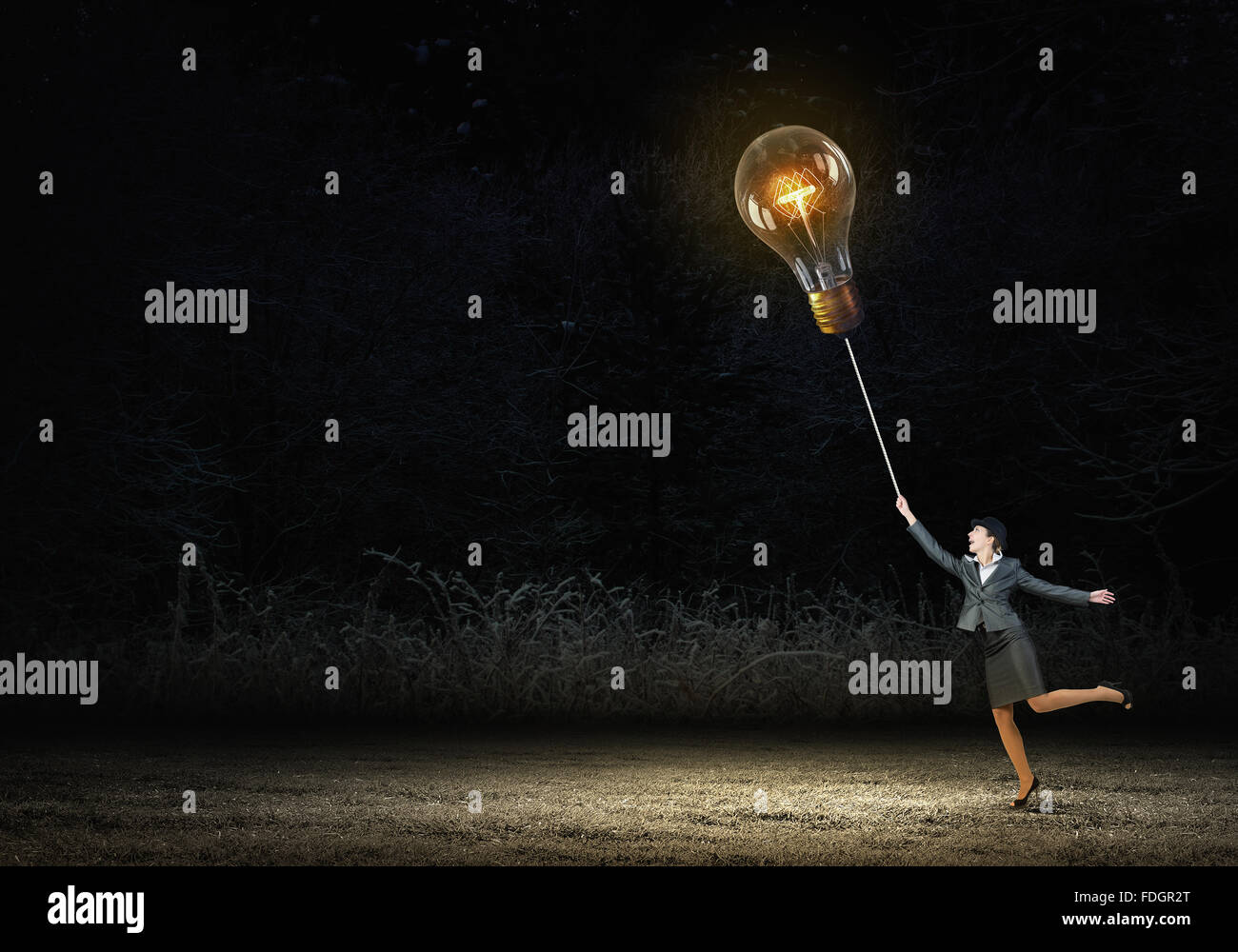 Businesswoman in bowler hat pulling rope with glass light bulb Stock ...