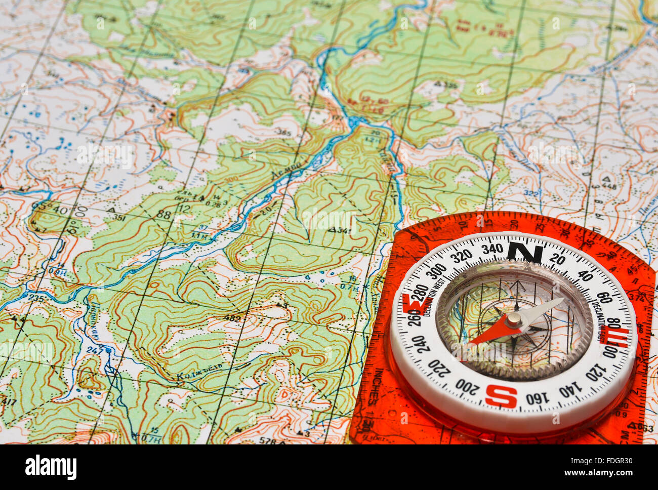 Compass and map. The magnetic compass is lying on a topographical map ...