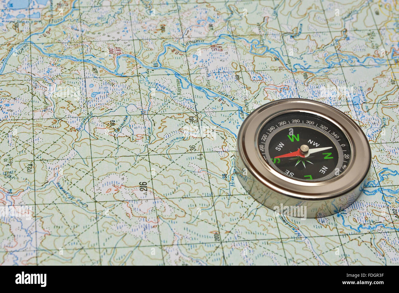 Compass and map. The magnetic compass is lying on a topographical map ...