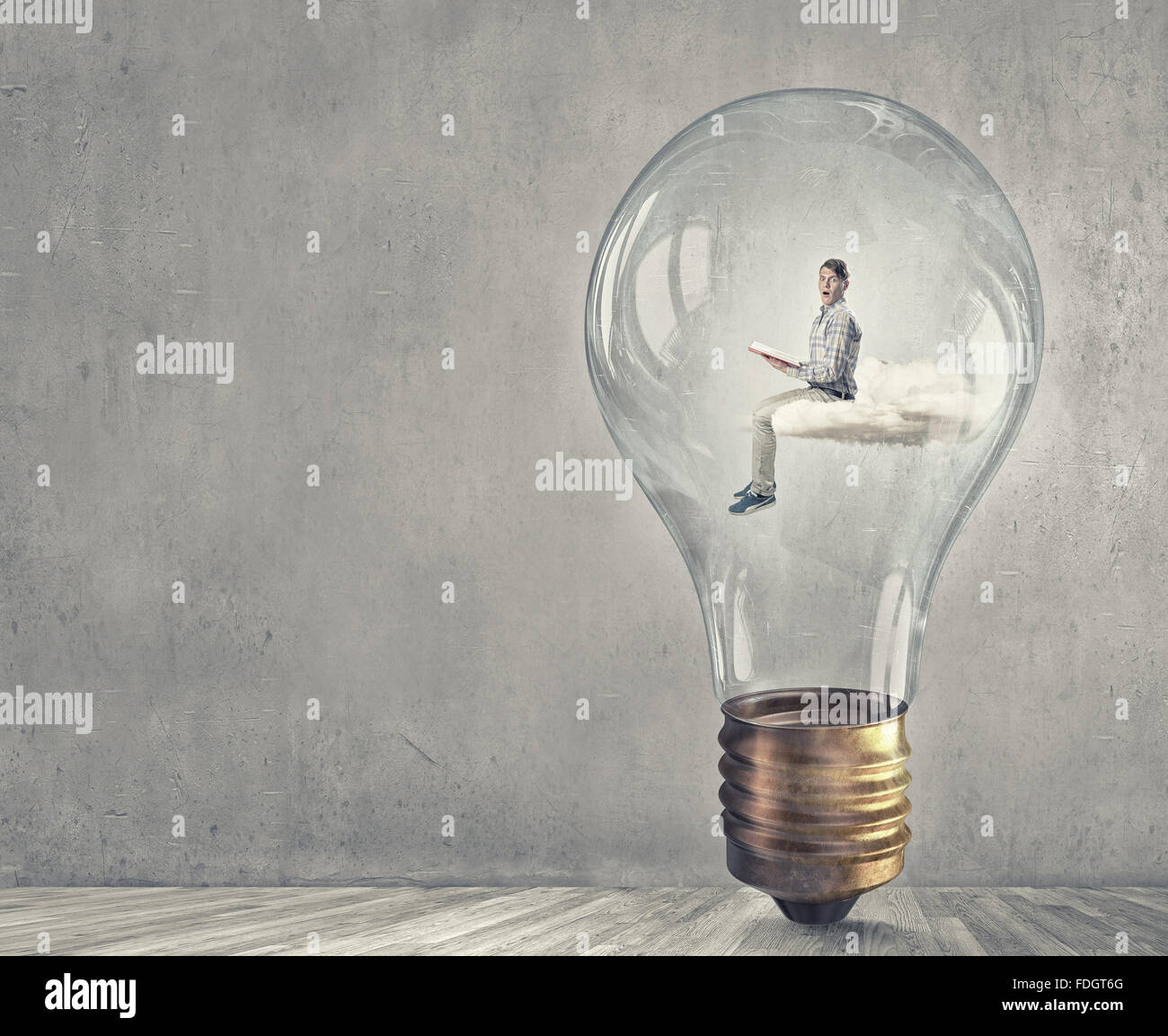 Young businessman inside of light bulb reading book Stock Photo - Alamy