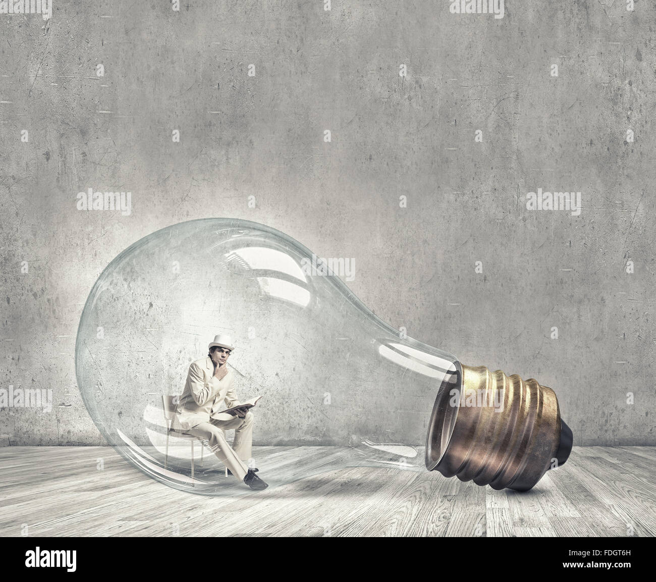 Young businessman inside of light bulb reading book Stock Photo - Alamy