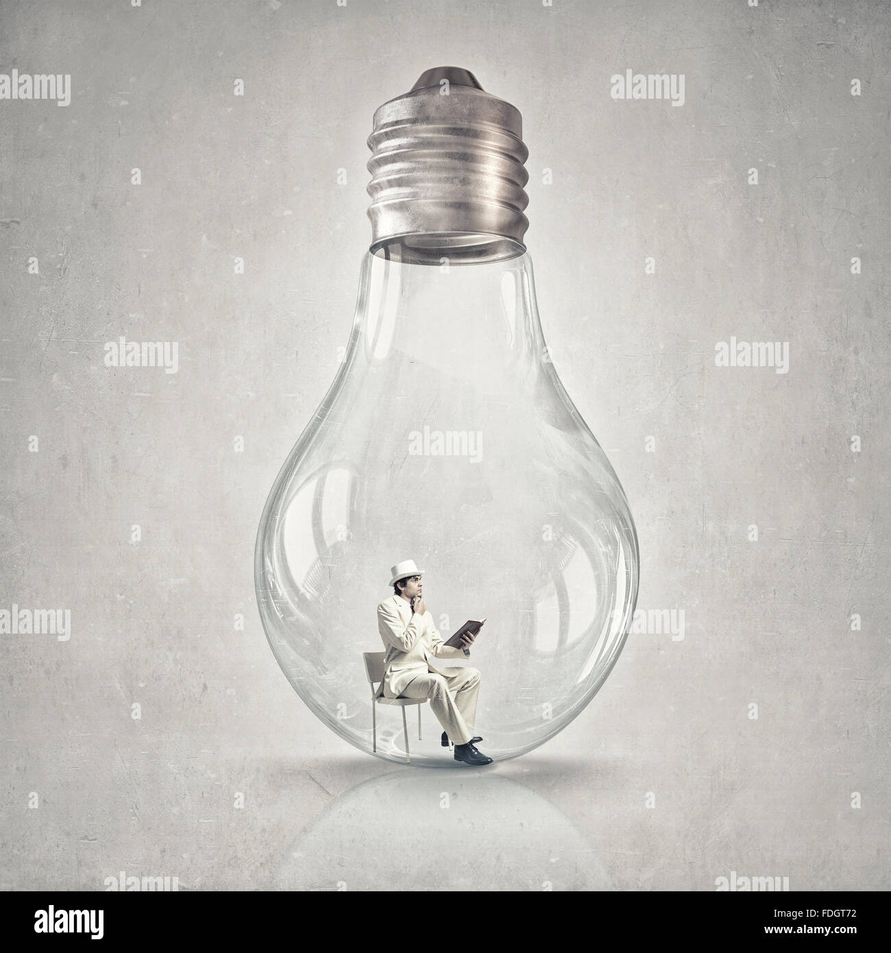 Young businessman inside of light bulb reading book Stock Photo - Alamy