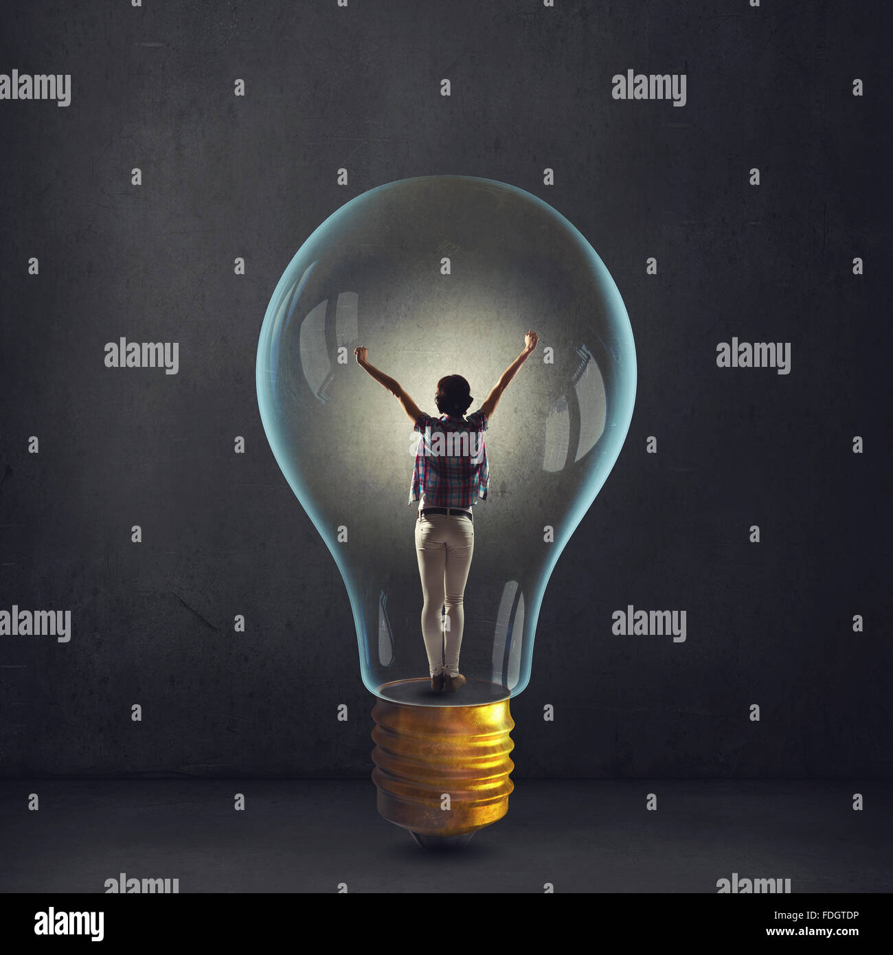 Cheerful girl inside of glass light bulb on dark background Stock Photo ...