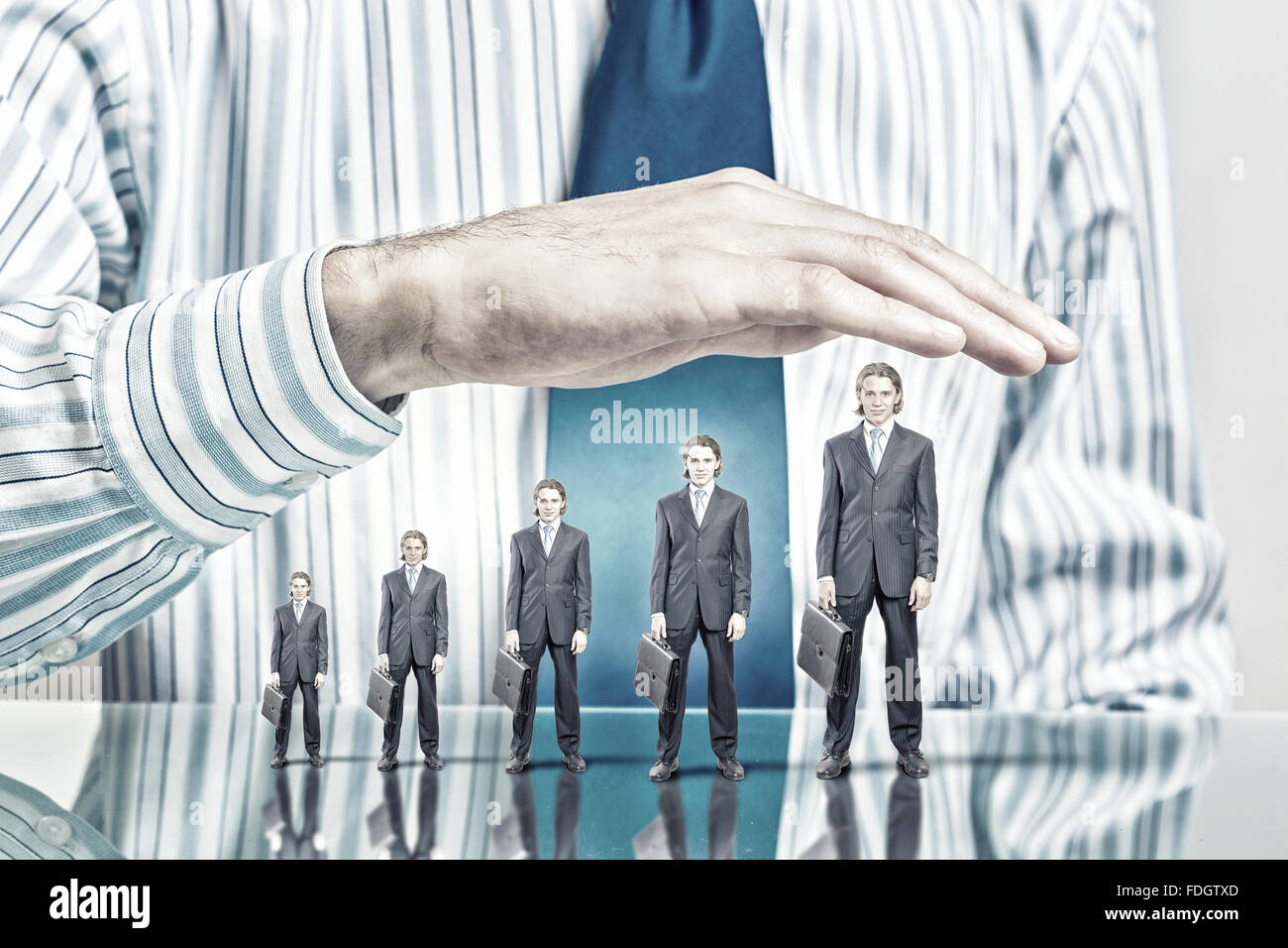 Male hand protecting business people of different size Stock Photo - Alamy