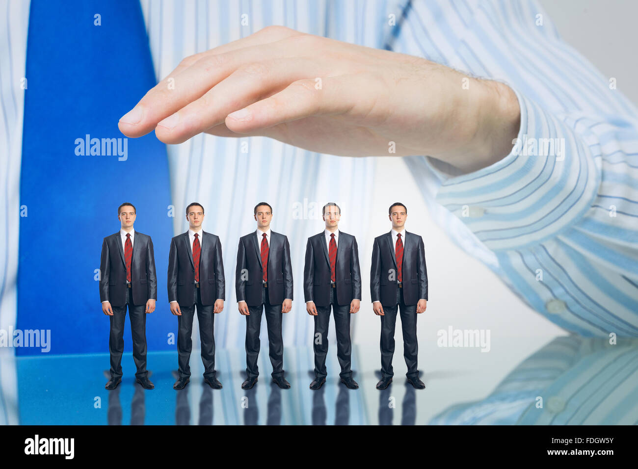Male hand protecting business people of different size Stock Photo - Alamy