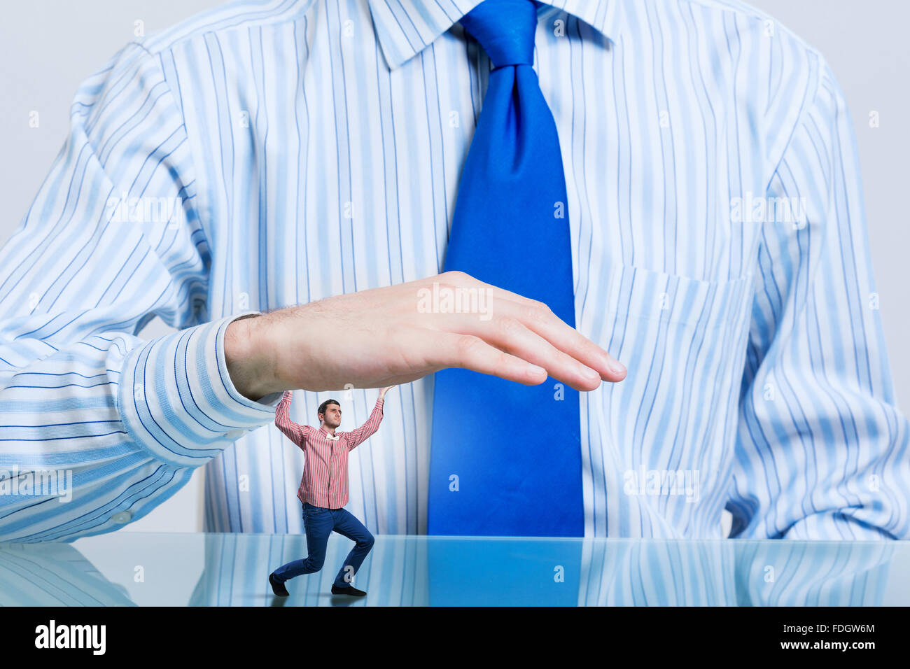 Young man under pressure of human big hand Stock Photo - Alamy