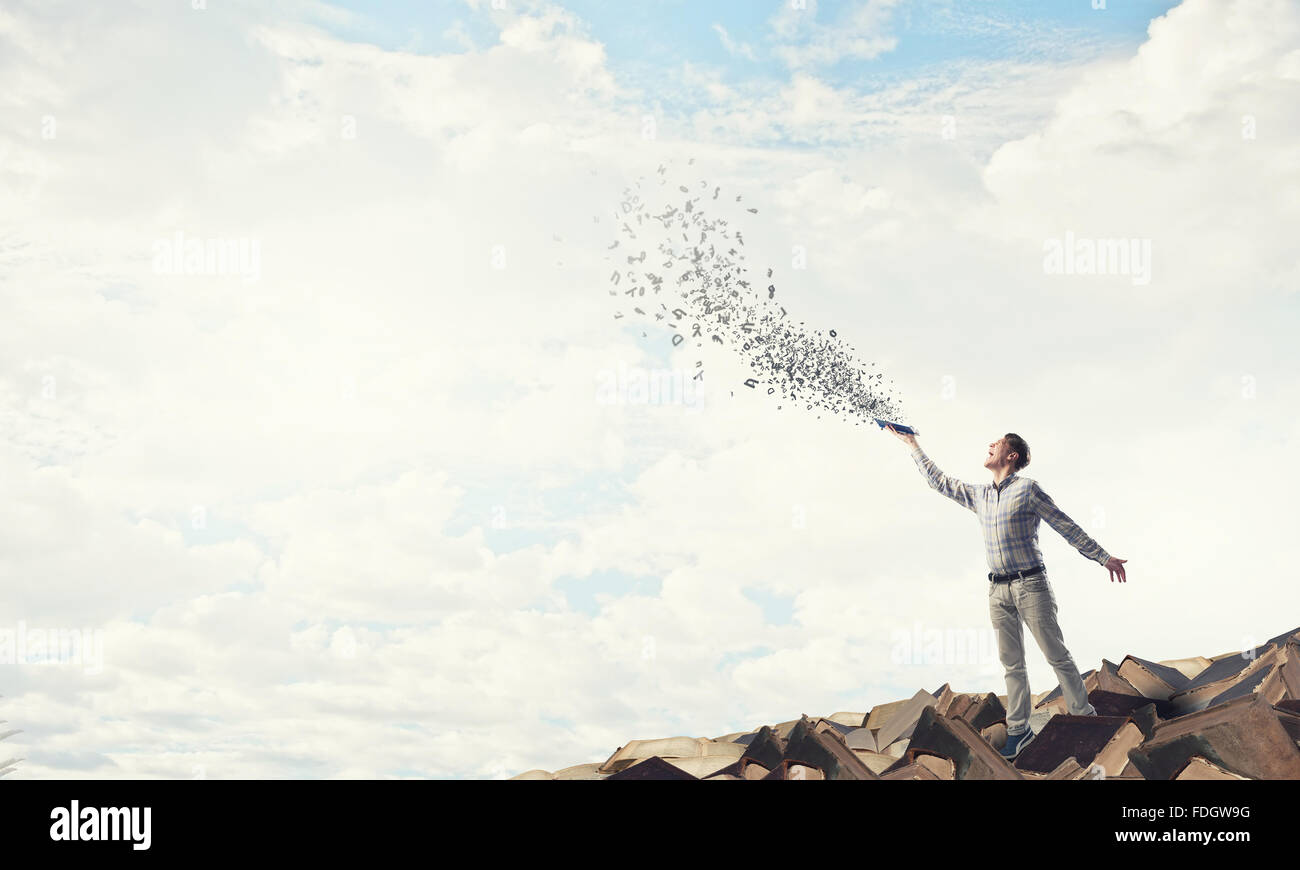 Young handsome man reaching hand with book and characters flying out ...