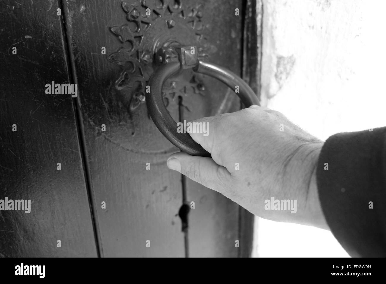 Pulling on the door, a man's hand on an old door latch Stock Photo - Alamy
