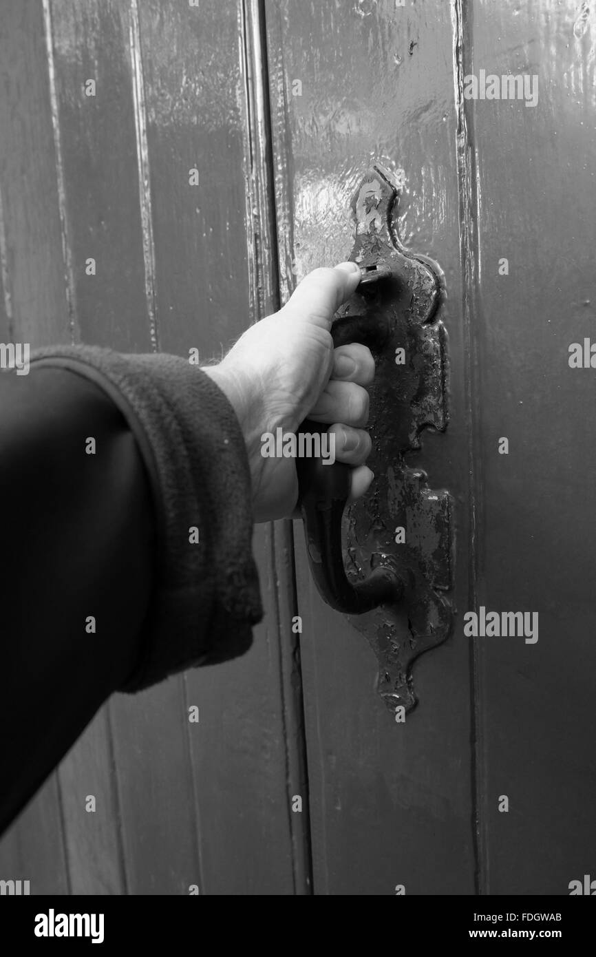 Pulling on the door, a man's hand on an old door latch Stock Photo - Alamy