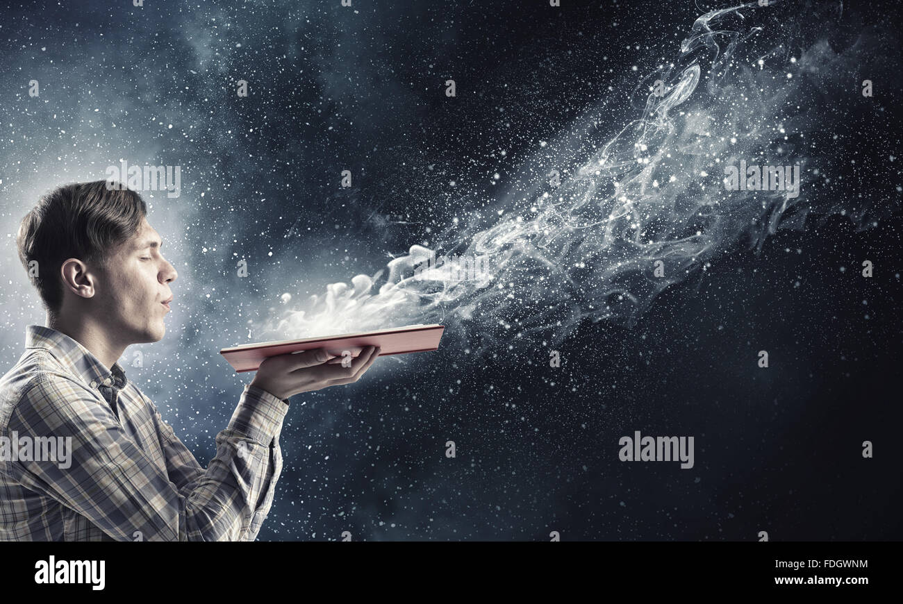 Young businessman with opened book in hands blowing on pages Stock ...