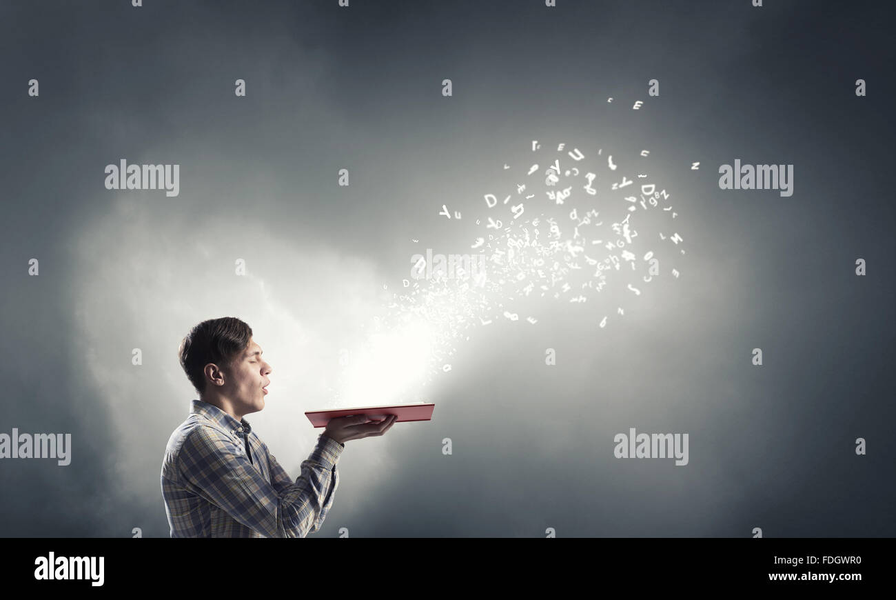 Young businessman with opened book in hands blowing on pages Stock ...
