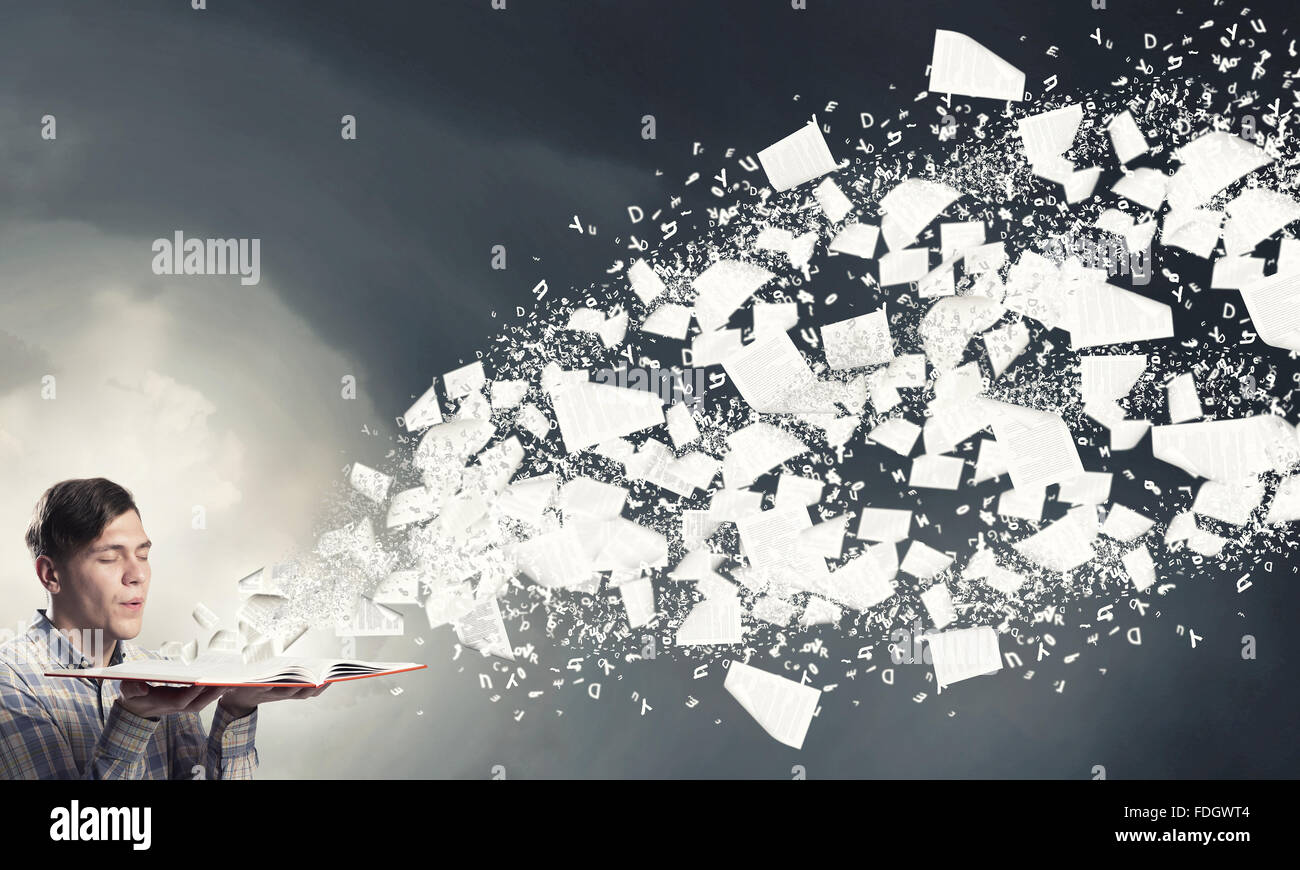 Young businessman with opened book in hands blowing on pages Stock ...