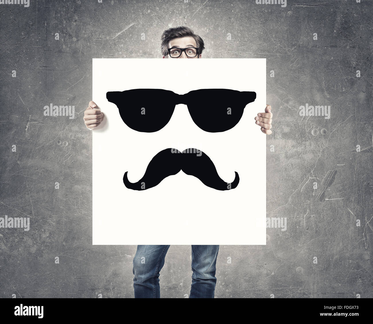 Businessman holding and hiding behind card with smiley face emoticon ...