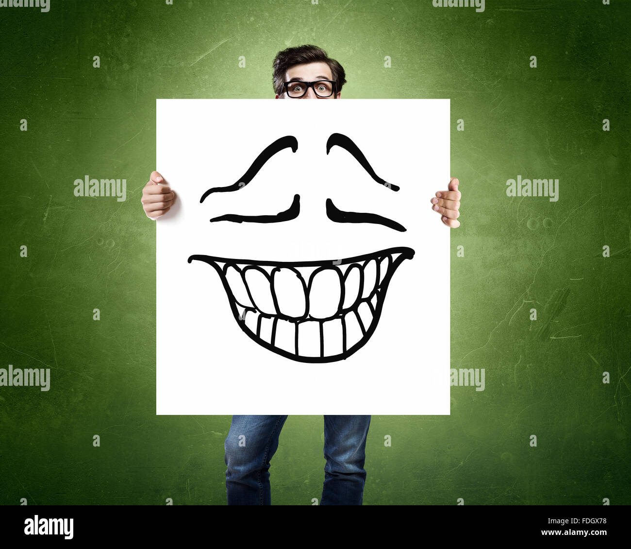 Businessman holding and hiding behind card with smiley face emoticon ...