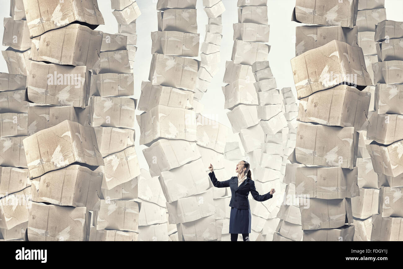 Businesswoman screaming among pile of carton boxes Stock Photo - Alamy