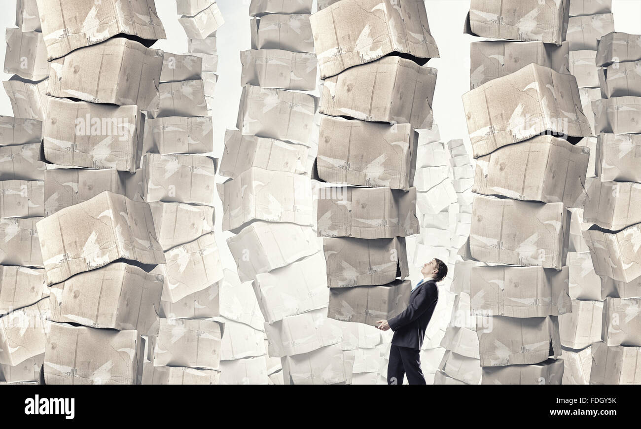 Businessman carrying big stack of carton boxes Stock Photo - Alamy