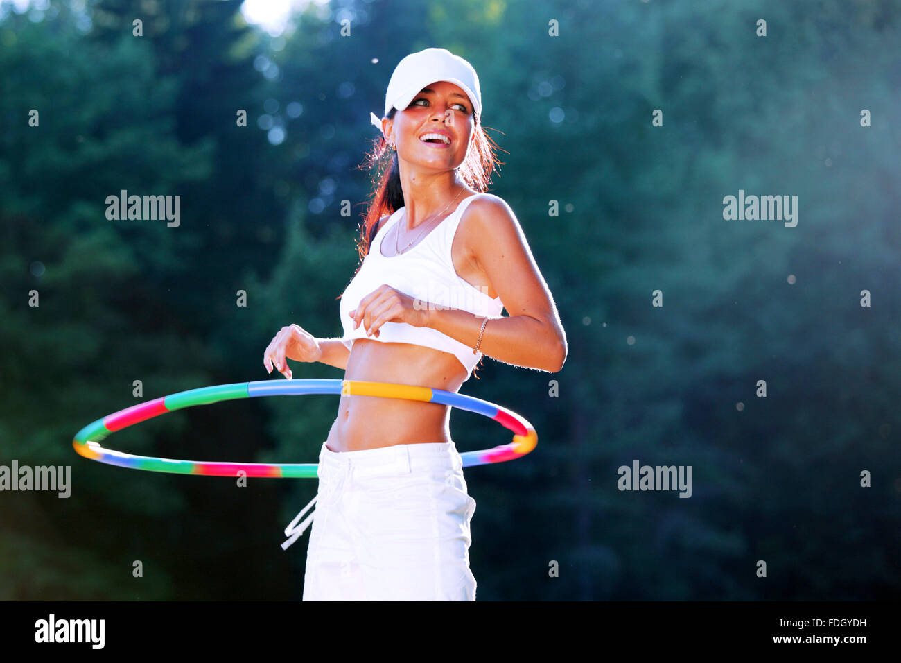 woman rotates hula hoop on nature background Stock Photo - Alamy