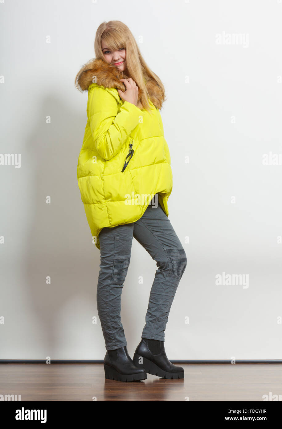 Beautiful smiling young fashionable girl wearing jacket with hood ...