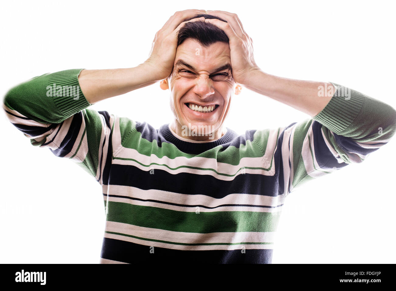 Portrait of a smart serious young man standing against white background ...