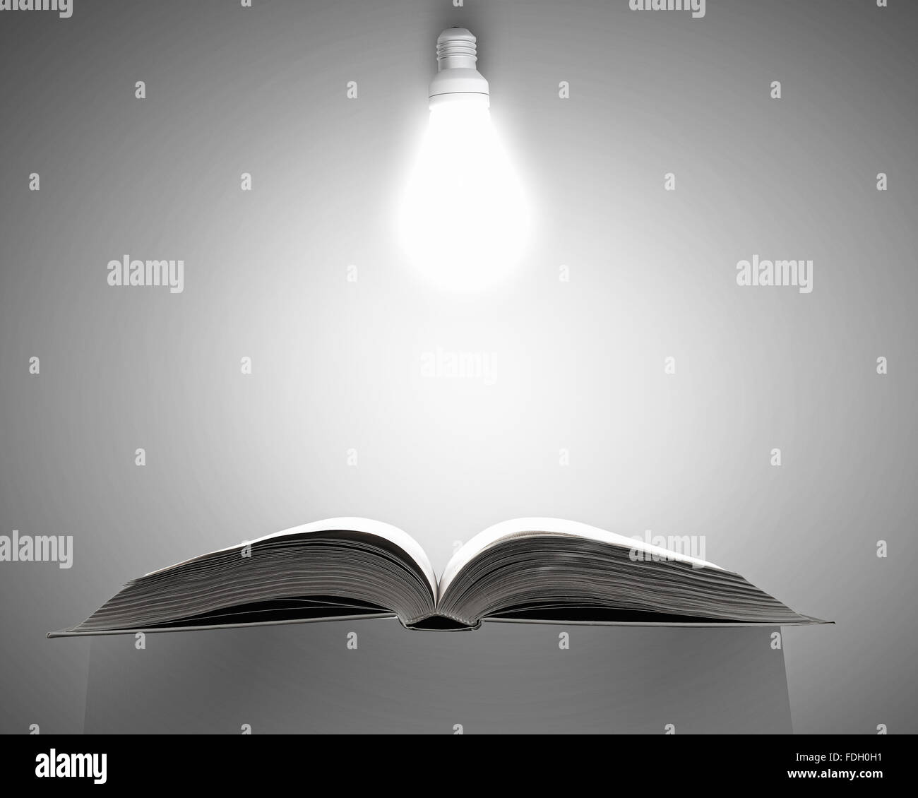 Opened book and glowing light bulb above pages Stock Photo - Alamy